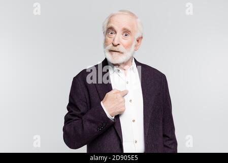Happy and surprised man pointing at himself, smiling pleased, standing ...