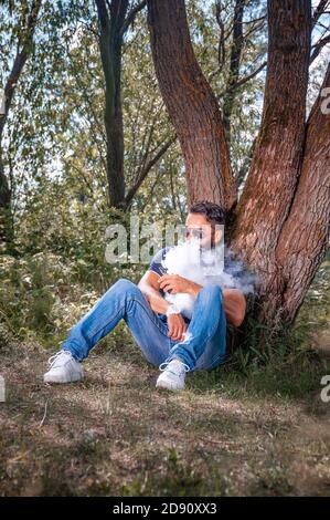 Confident smoker enjoying an electronic smoke device in the calm ...