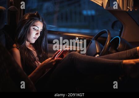 Woman using smartphone inside a car Stock Photo - Alamy