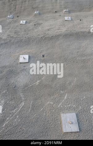 Cement clad chain link rockfall protection with anchors visible on the ...