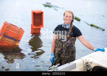 portrait of female shellfish farmer standing in water Stock Photo - Alamy