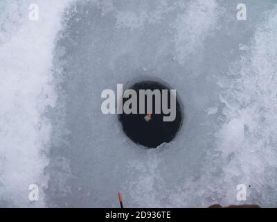 Winter fishing. Fishing rod stands on the ice. Fishing theme Stock ...