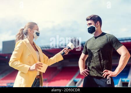 Reporter doing interview with football player during covid-19 Stock ...