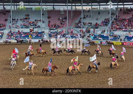 Rodeo cowgirl riding horse carrying American flag during the 4th Annual ...