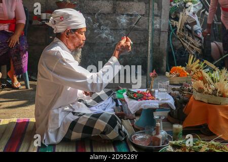 Hindu priest wearing a white uniform was carrying out a religious ...