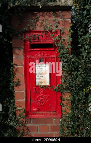 Bright red British postbox mounted into a wall Stock Photo - Alamy
