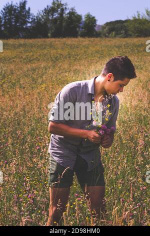 Young man collecting flowers for his lover Stock Photo - Alamy