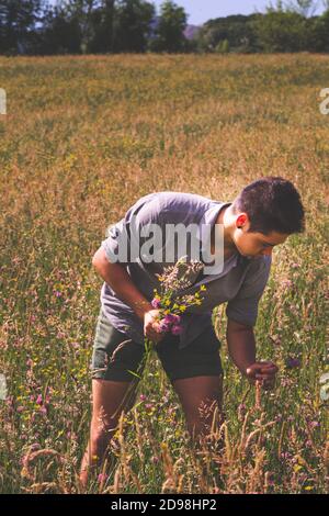 Young man collecting flowers for his lover Stock Photo - Alamy