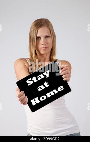 Woman Holding a Sign that says "Stay at Home Stock Photo - Alamy