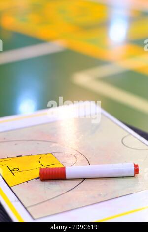 scheme basketball game on clip board paper with marker and wooden table ...