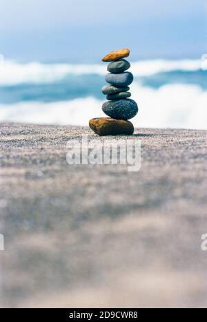 Balanced rocks on a beach with waves Stock Photo - Alamy