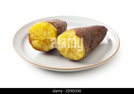 Sweet potatoes broken in half on a white background on a plate Stock ...