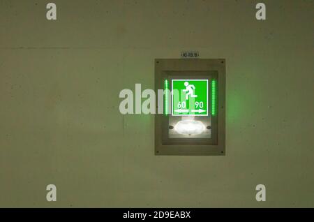Illuminated emergency exit sign in a motorway tunnel, guiding you to an ...