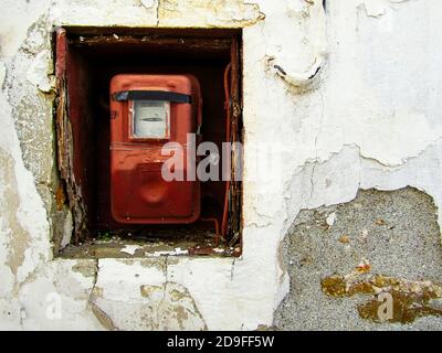 A traditional old style electricity meter in an outdoor meter cupboard ...