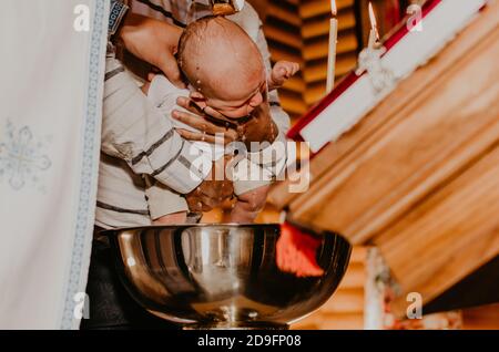 priest washes child with Sacred water. rite of sacrament of epiphany ...