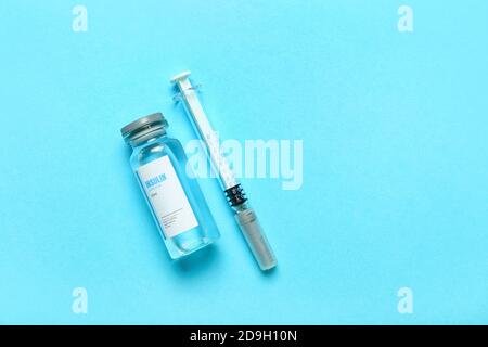 Bottle of insulin with syringe on color background. Diabetes concept ...