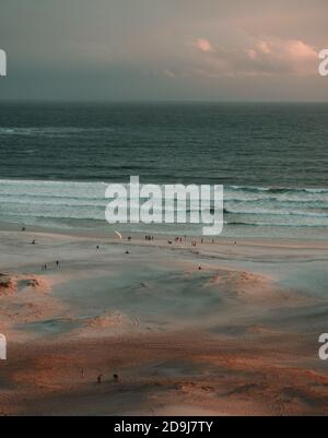 Vertical shot of sandy beach and wavy sea at sunset Stock Photo - Alamy