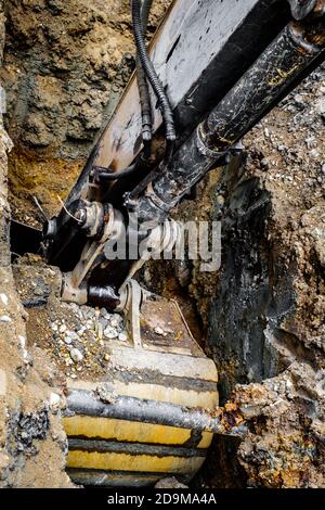 Excavator operating in front of a large salt pile with a clear blue sky ...