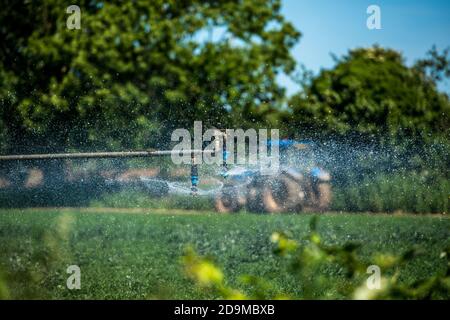 Tractor irrigating field Stock Photo - Alamy