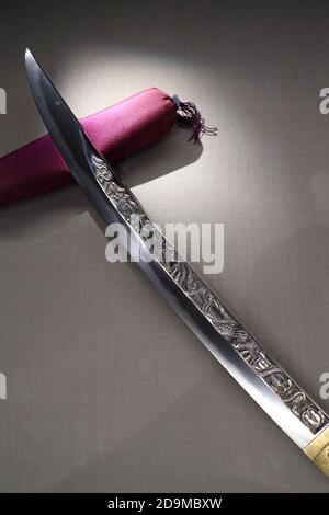 A closed up view of a small Tachi sword with engravings from Momyama ...