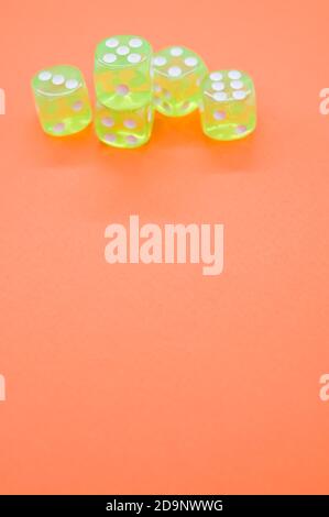 A top view closeup of five neon green dice isolated on a bright pink ...