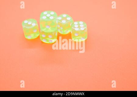 A top view closeup of five neon green dice isolated on an orange ...