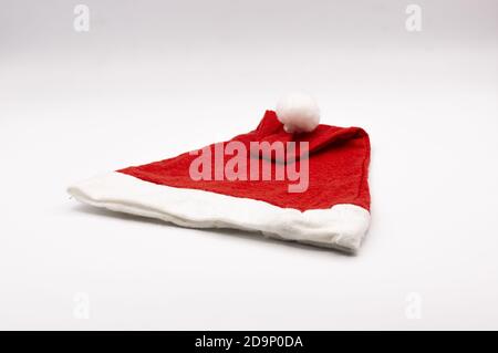 Closeup shot of a Santa hat and red Christmas tree ornaments on a ...