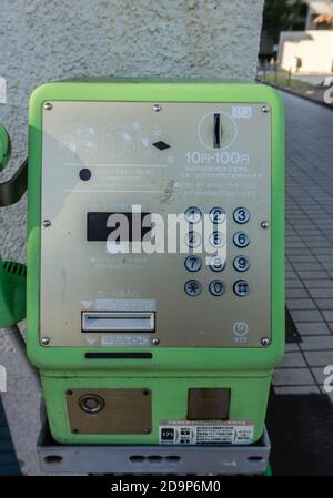 Old fashioned green Japanese NTT public telephone in a street in Kyoto ...