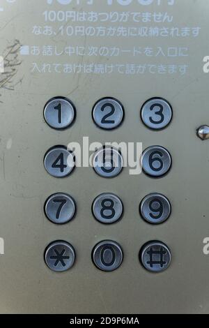 Old fashioned green Japanese NTT public telephone in a street in Kyoto ...