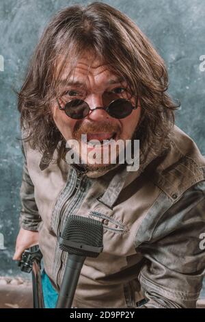 Mature rocker with microphone emotional studio portrait Stock Photo - Alamy