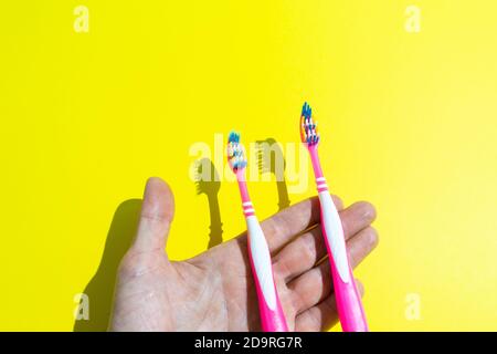 holding a toothbrush. old and new toothbrushes are located side by side ...