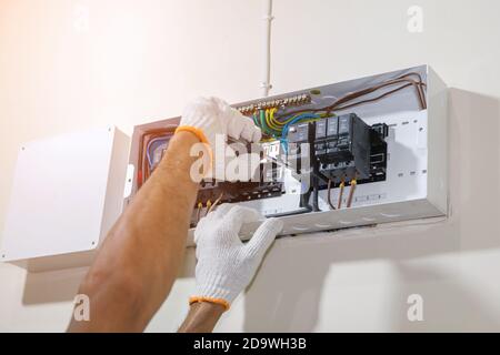 Closeup of hands of electrician using a screwdriver to tighten the ...