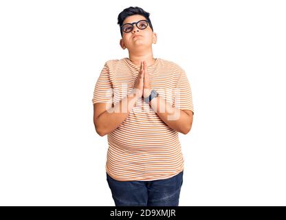 Cute little boy begging for his request, holding hands together, orange ...