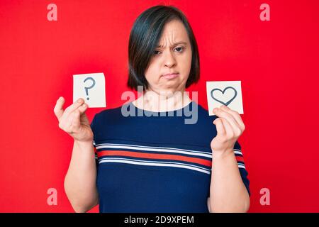 Emotional woman with question mark sticker on forehead against black ...