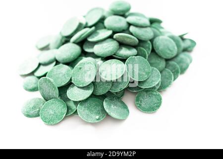 Green round chocolate chips for melting chocolate shapes on a white ...