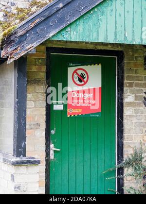 A derelict building with a warning sign "Danger unsafe building keep ...