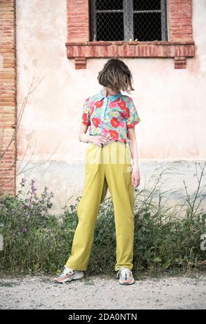 Full length faceless slim female wearing stylish outfit strolling on ...