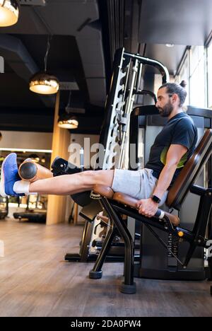 Athlete Doing The Leg Extension Machine Training Stock Photo - Alamy