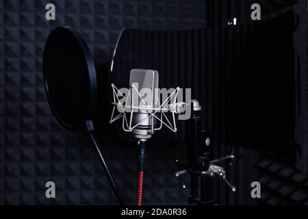 Contemporary metal microphone with wire placed in dark music recording ...