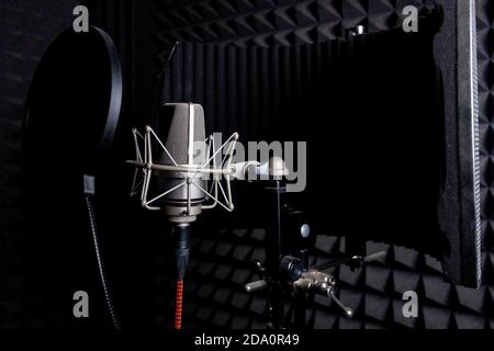 Contemporary metal microphone with wire placed in dark music recording ...