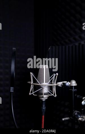 Contemporary metal microphone with wire placed in dark music recording ...