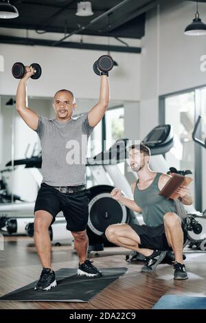smiling man exercising in gym Stock Photo - Alamy