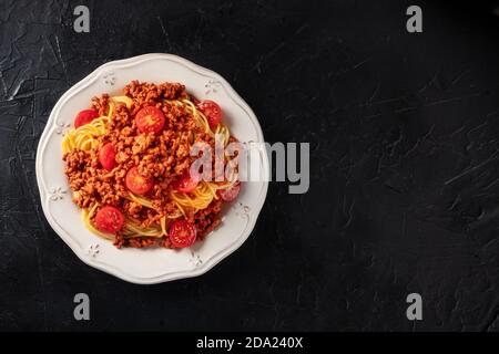 Spaghetti bolognese pasta, top-down shot on a dark background with ...