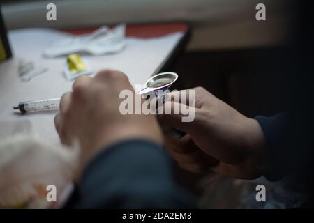 A drug addict taking intravenous injection in a "shooting gallery", a ...