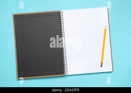 flat lay with opened blank notebook with paper clips, color pencils and ...