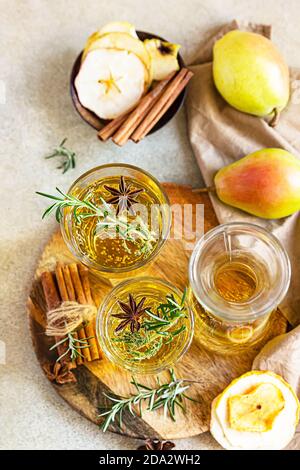 Pear cider cocktail with rosemary in tall glasses and bottle and fresh ...