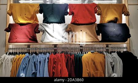 Bright colorful sweatshirts hanging at a fashion store. Closeup of ...