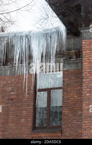 Large ice stalactites hang from the high cliff Stock Photo - Alamy