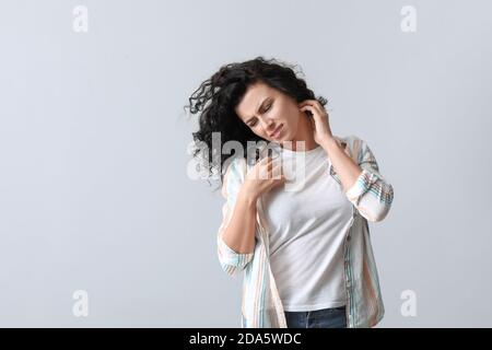 Young woman scratching herself on color background Stock Photo - Alamy