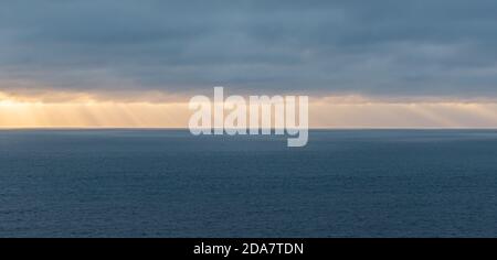 Sun rays coming down from the clouds over the ocean Stock Photo - Alamy